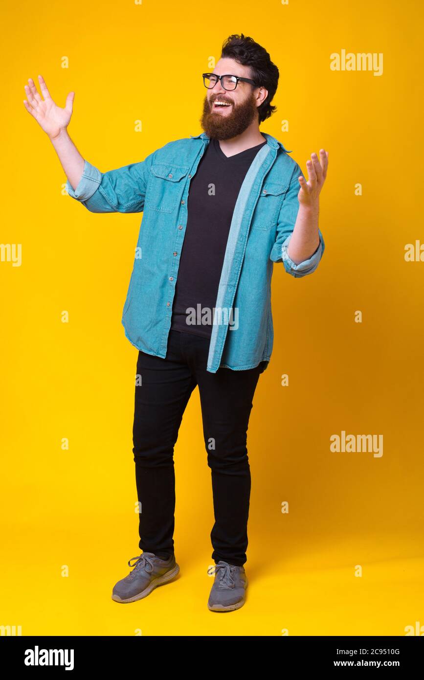 Full length photo of cheerful smiling young man making welcome gesture ...