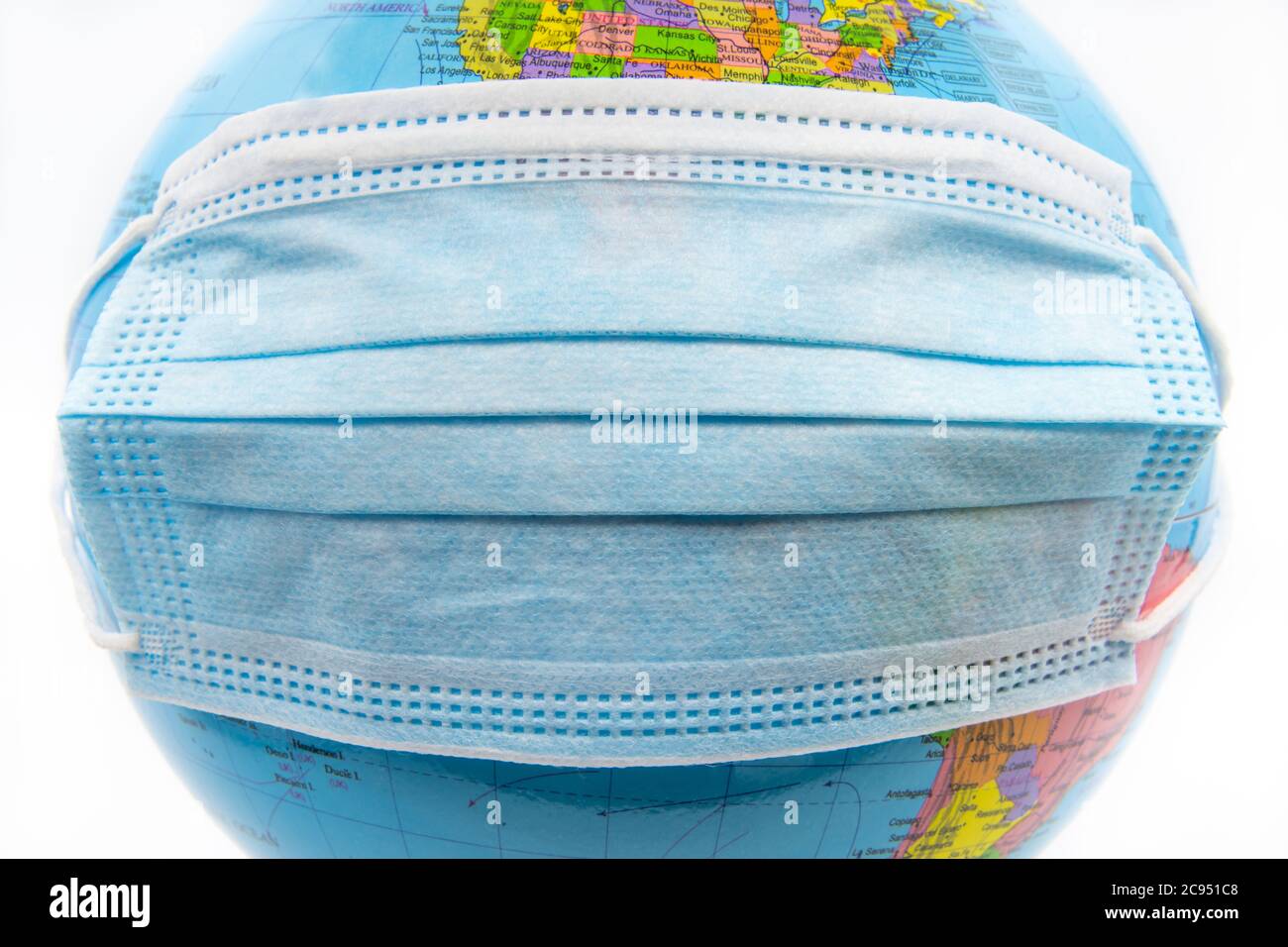 Single use medical face mask over world globe sphere model, coronavirus ...