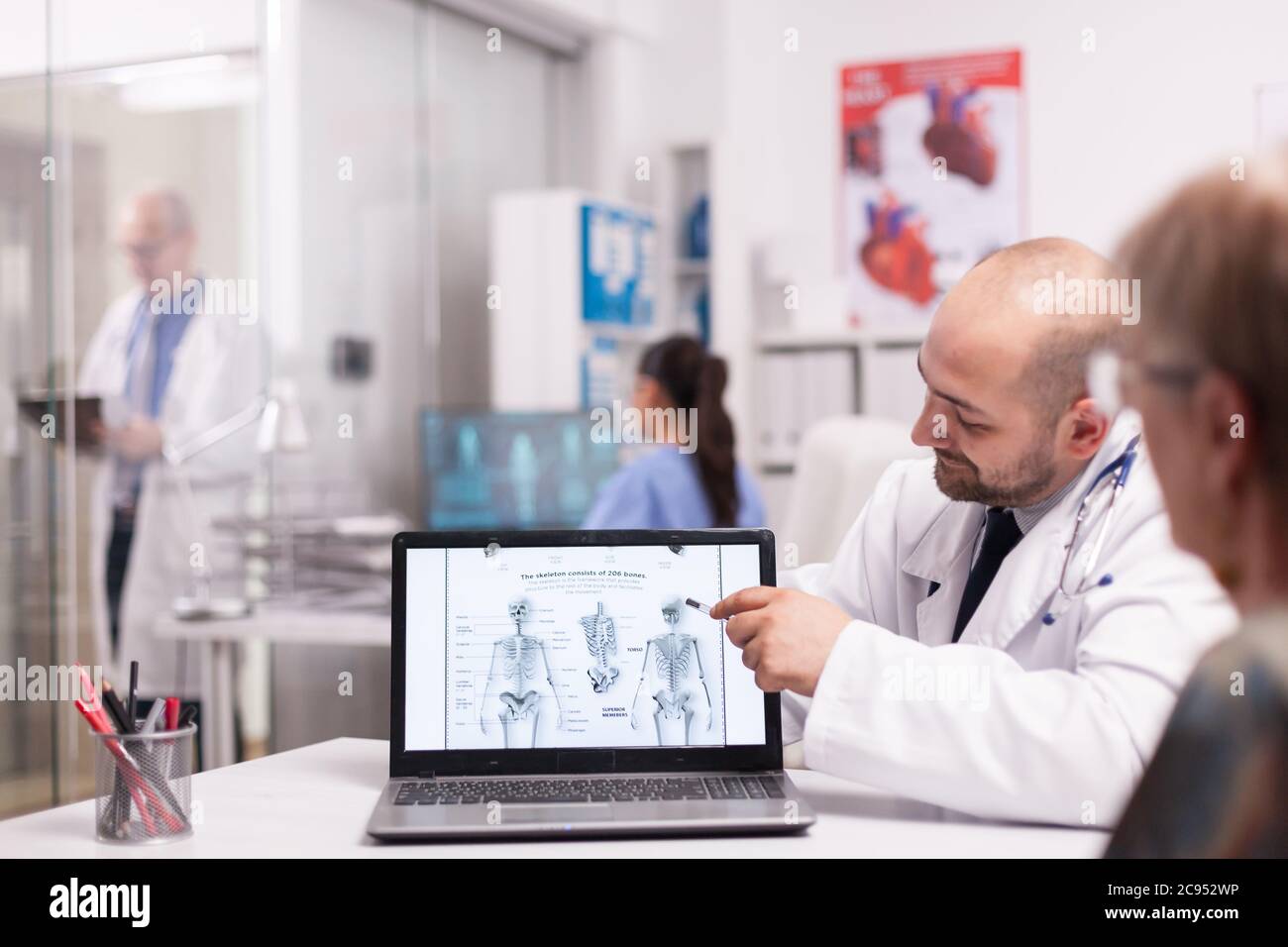 Doctor pointing laptop wearing hi-res stock photography and images - Alamy