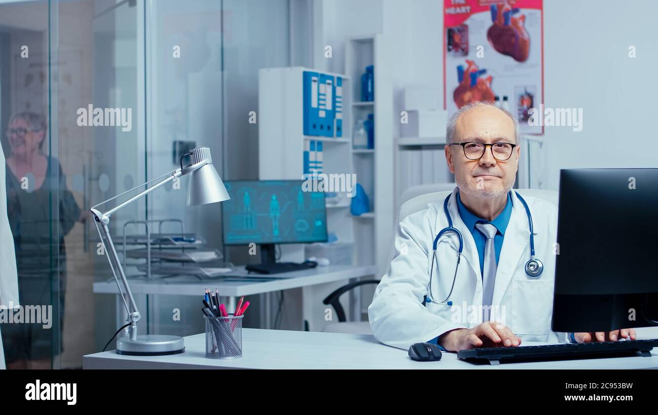 Doctor looking at camera after typing on the computer in a modern ...