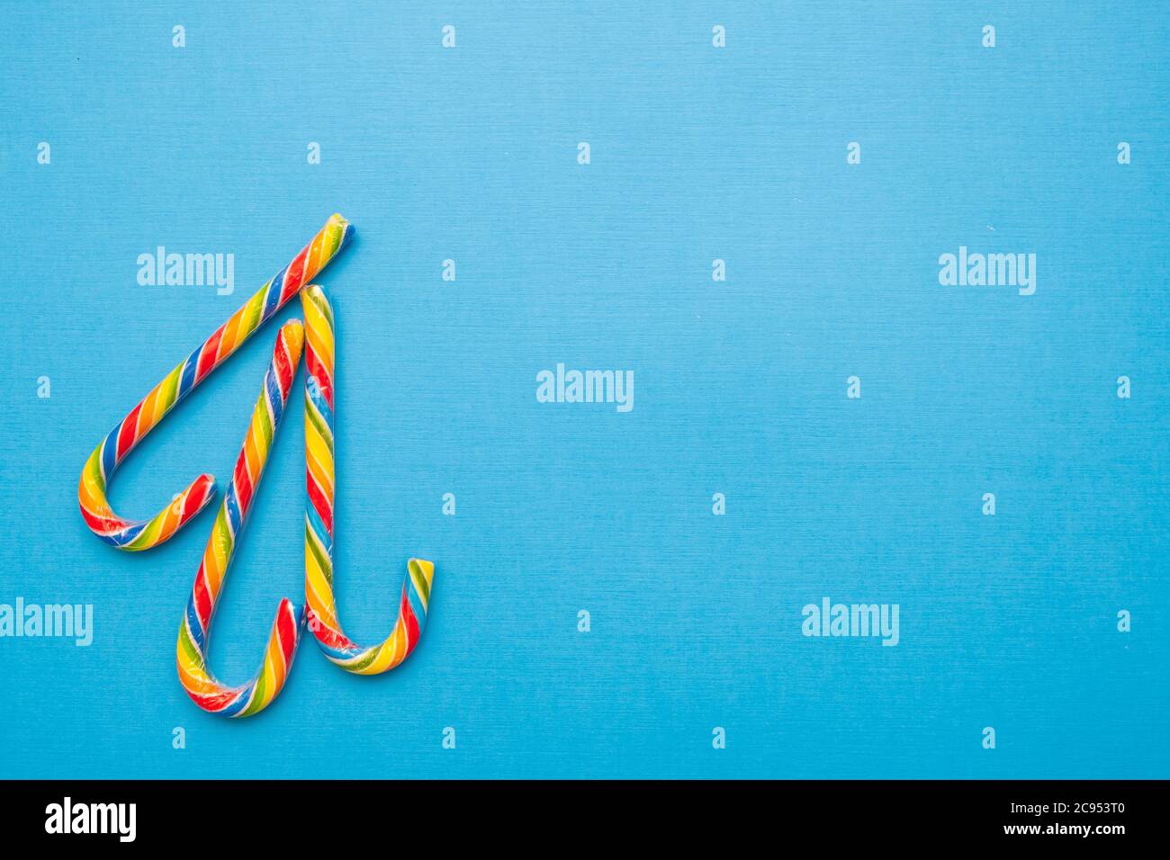 multi-colored candy canes on a blue background, copy space Stock Photo ...