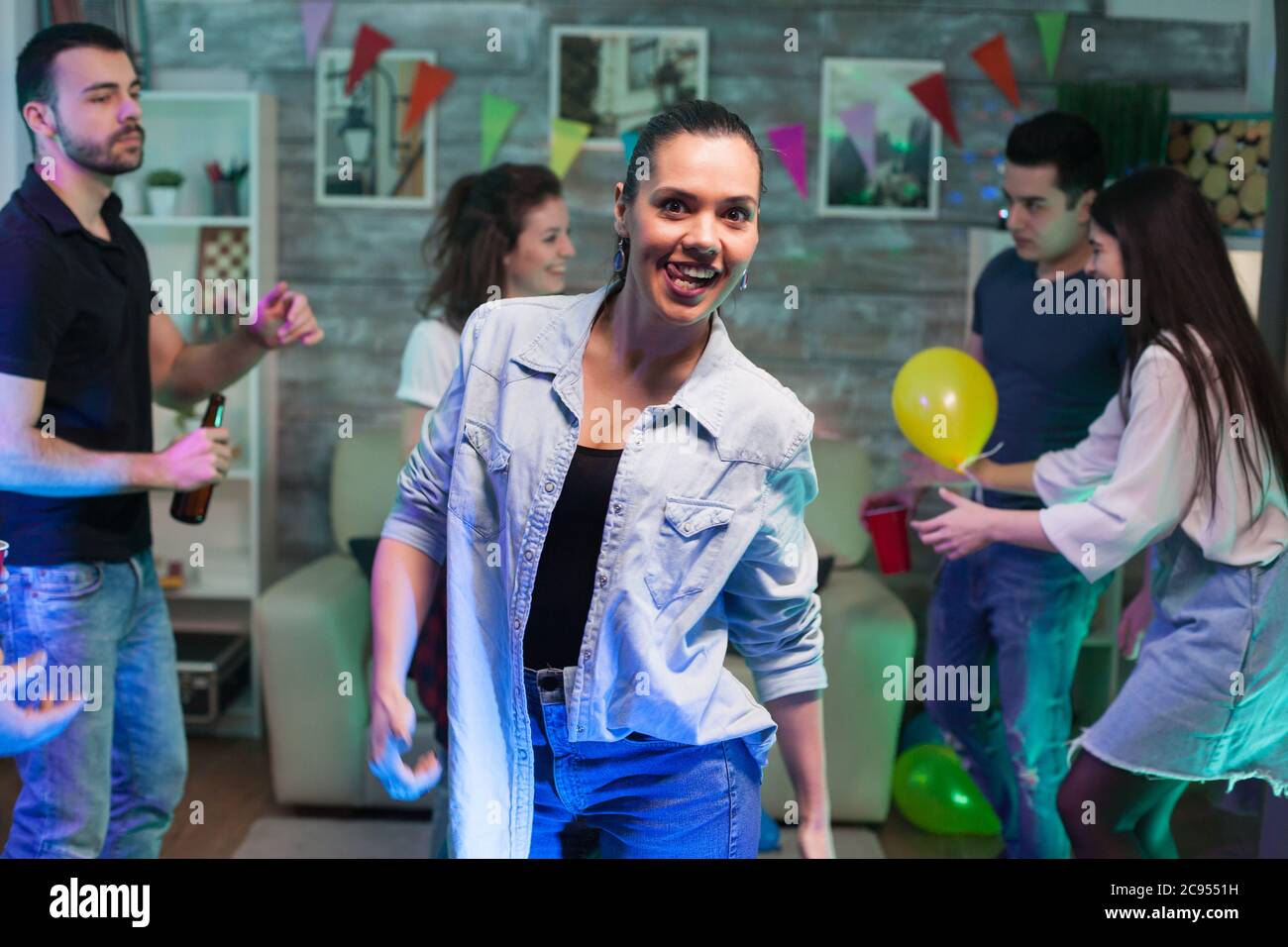 Joyful young woman with a big smile looking at the camera while ...