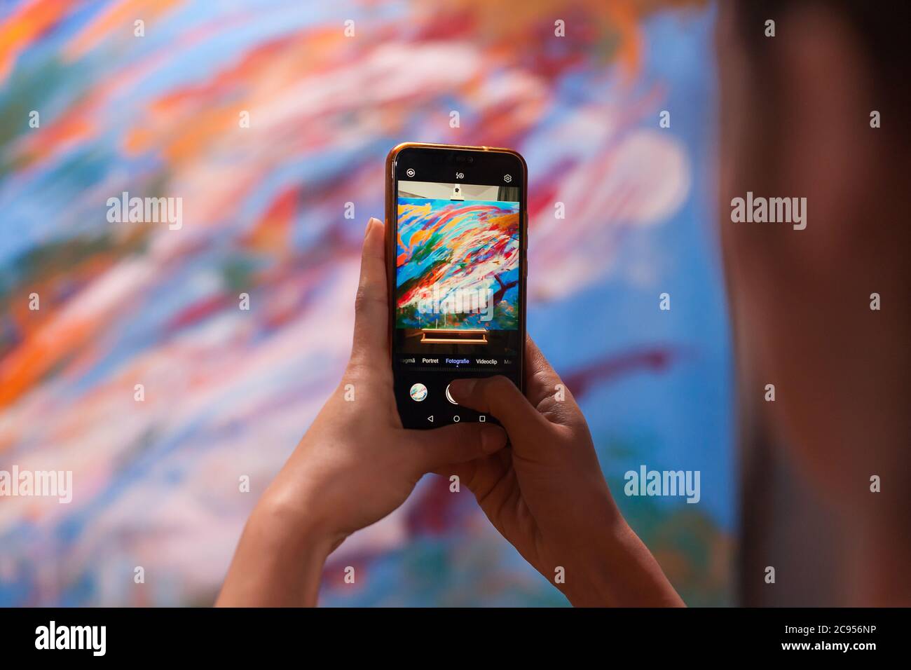 Artist taking photo of his masterpiece painting in art workshop. Modern ...