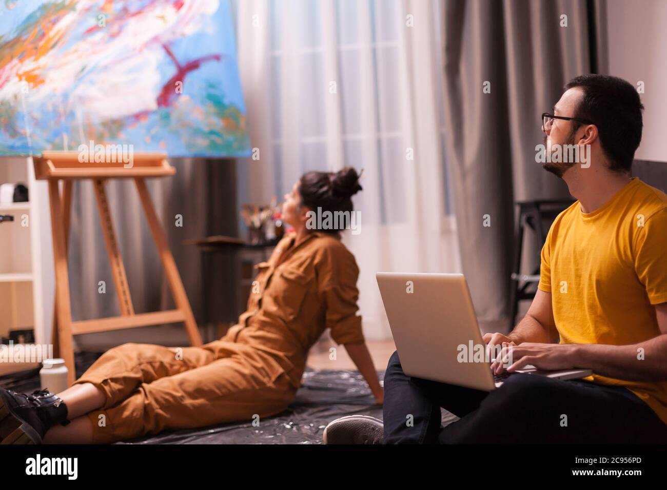 Artists searching for inspiration on internet in art workshop. Modern ...