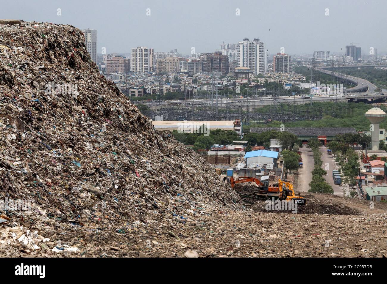 New Delhi, India. 28th July, 2020. A view of the Ghazipur landfill site with high rise city ...