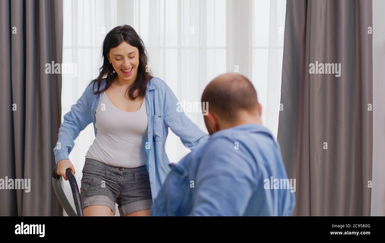 Happy young couple dancing while cleaning the house Stock Photo - Alamy