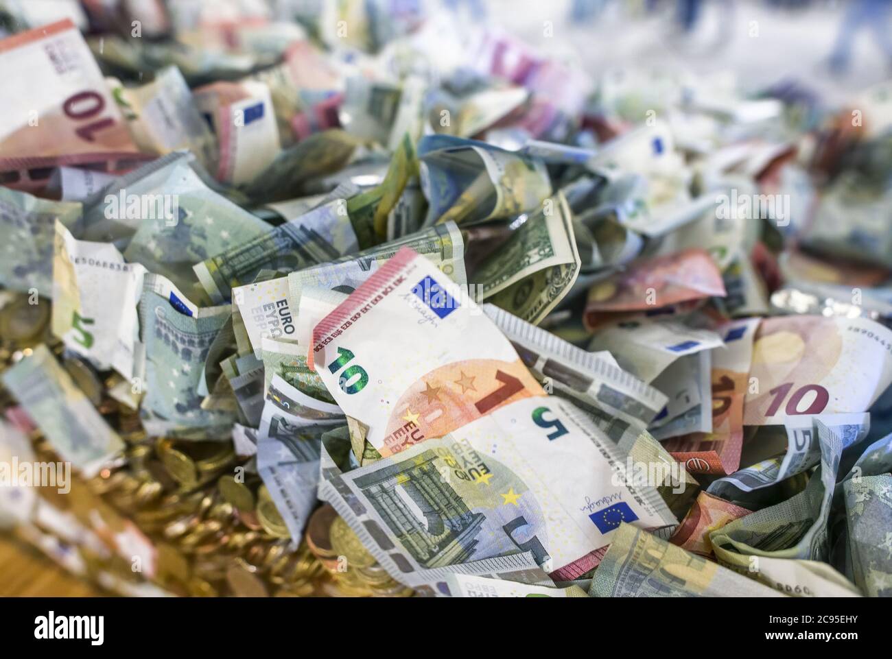 Composition of euro banknotes and coins in a giant bucket. Business ...