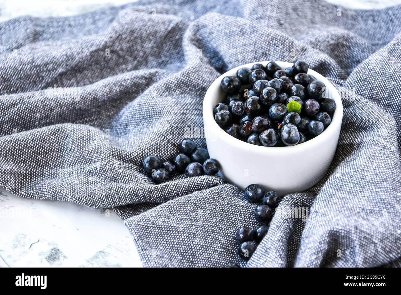 Small White Bowl of Organic Blueberries on Wooden Table with kitchen ...