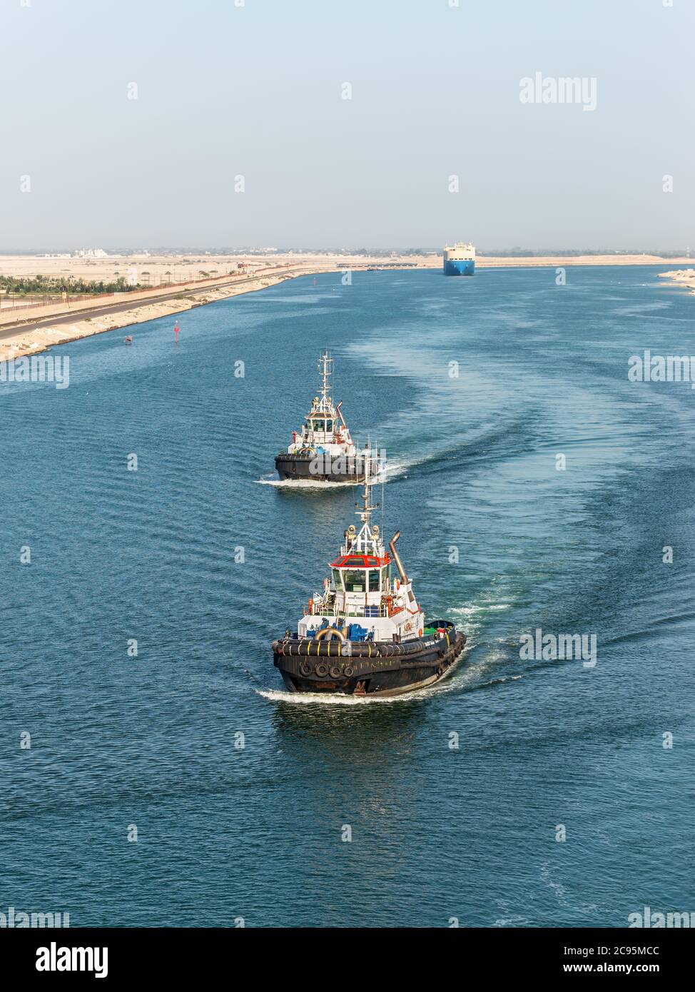 El Qantara, Egypt - November 14, 2019: Tugboats accompanies the ships. Ships passing through the ...