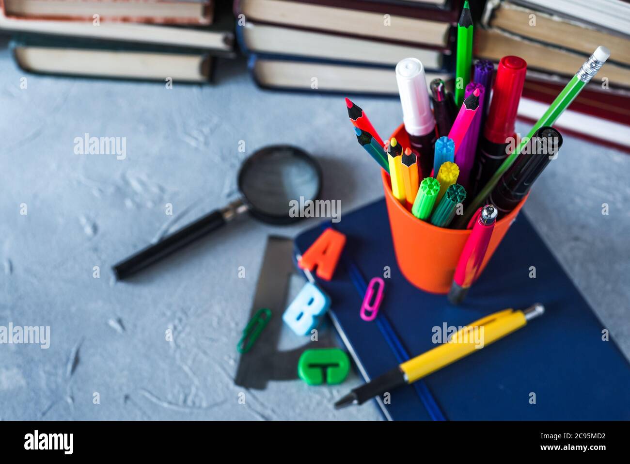 A stack of books and pencils on a desk in elementary school. A stack of ...