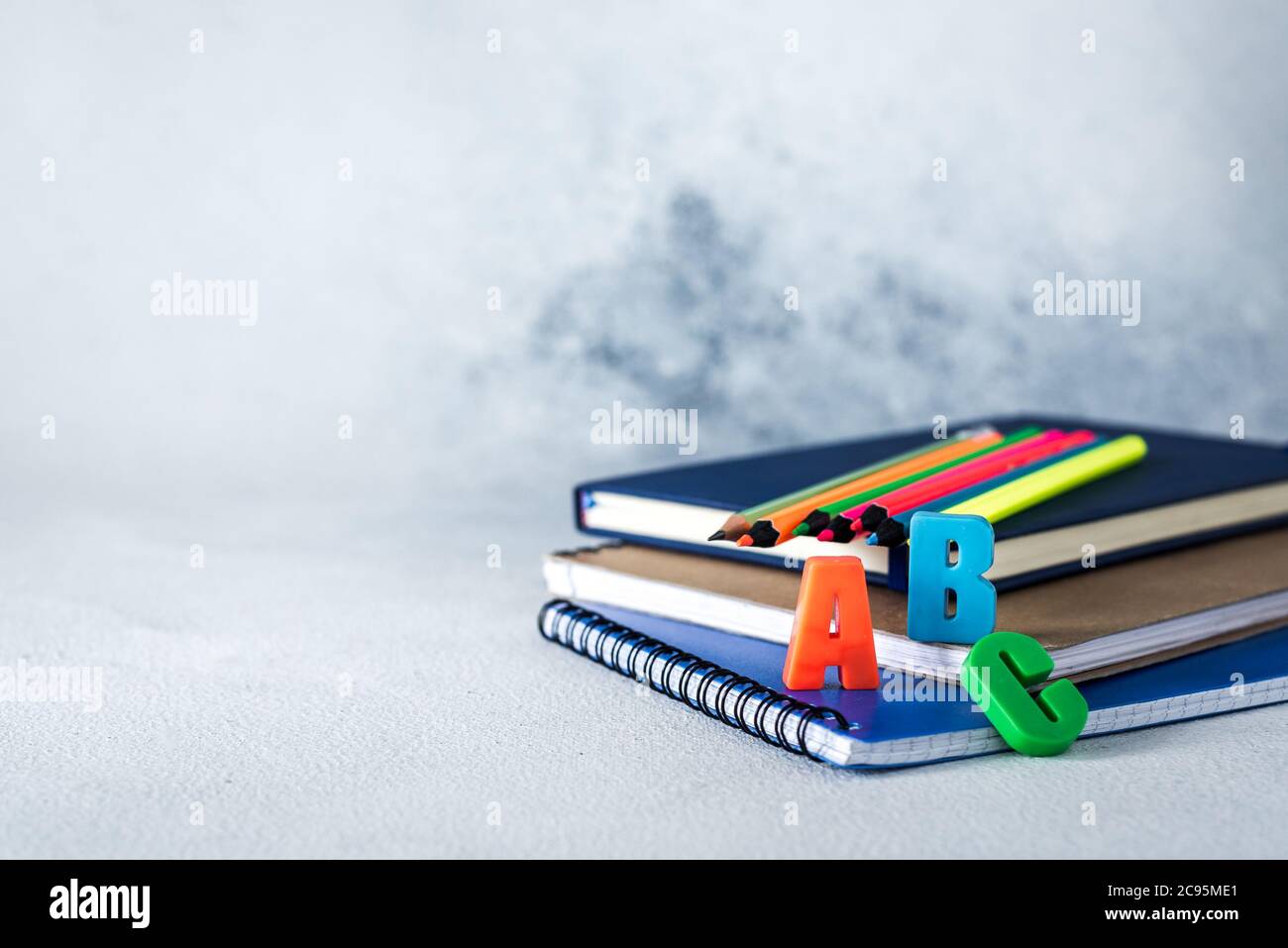 A stack of books and pencils on a desk in elementary school. A stack of ...