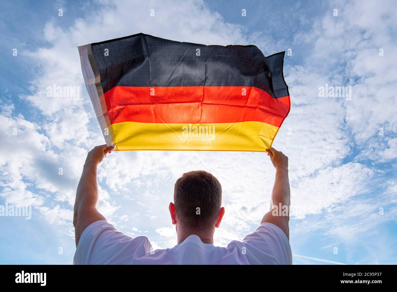 Man holding Flag of Germany, concept picture Stock Photo - Alamy