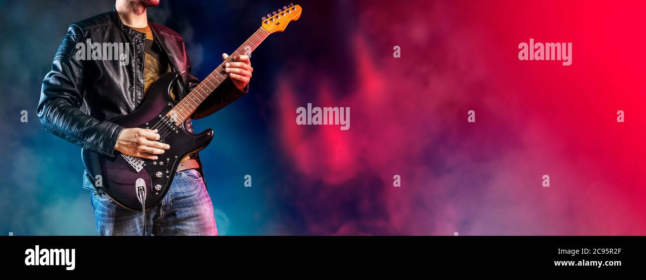 Guitar player performs on stage. Rock guitarist plays solo on an ...