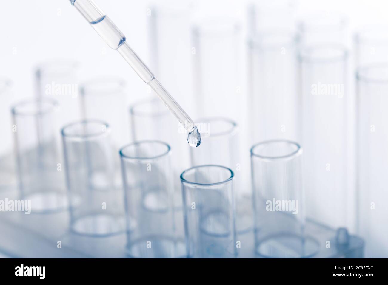 pipette with a drop and scientific laboratory test tubes in a research ...