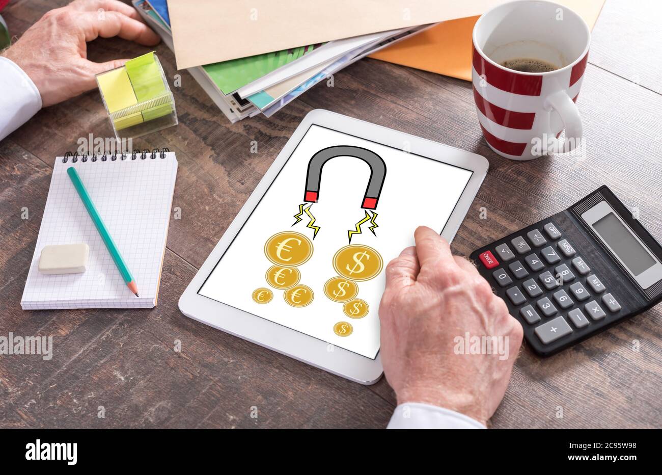 Man using a tablet showing a money attraction concept Stock Photo - Alamy