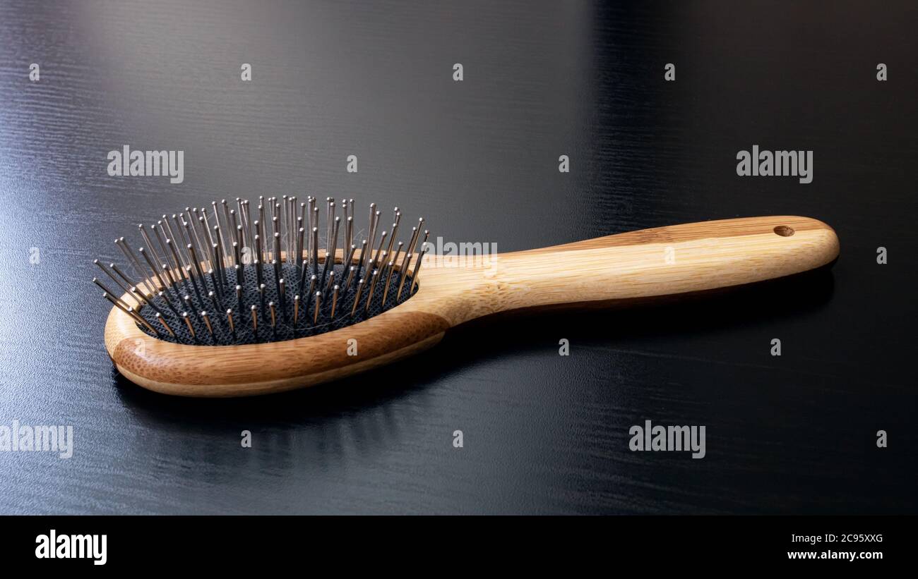 Wooden comb on a black background closeup Stock Photo - Alamy