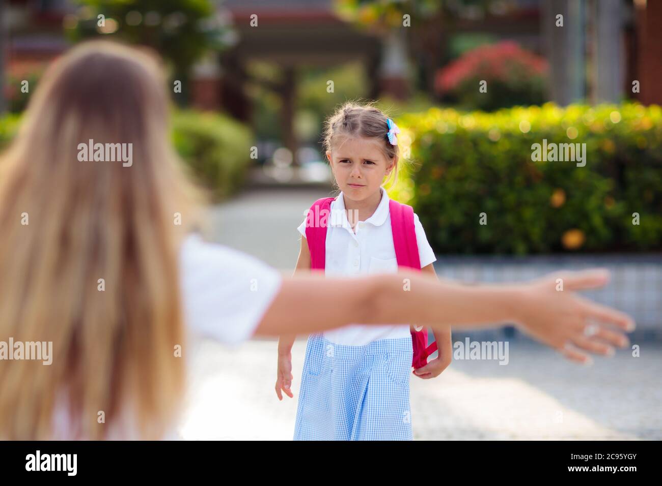 Mother and kids after school. Young mom picking up children after ...