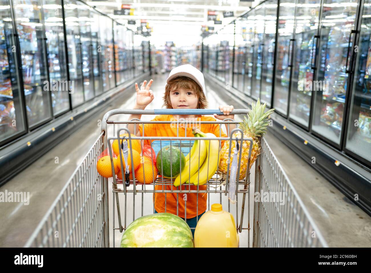 Toddler boy with shopping bag in supermarket. Child shopping in ...