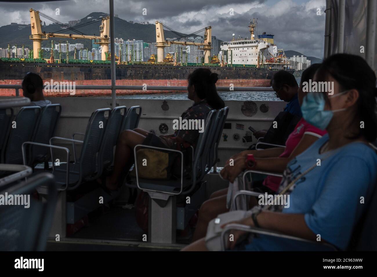Passengers on a ferry wear surgical masks during a trip between Lamma ...