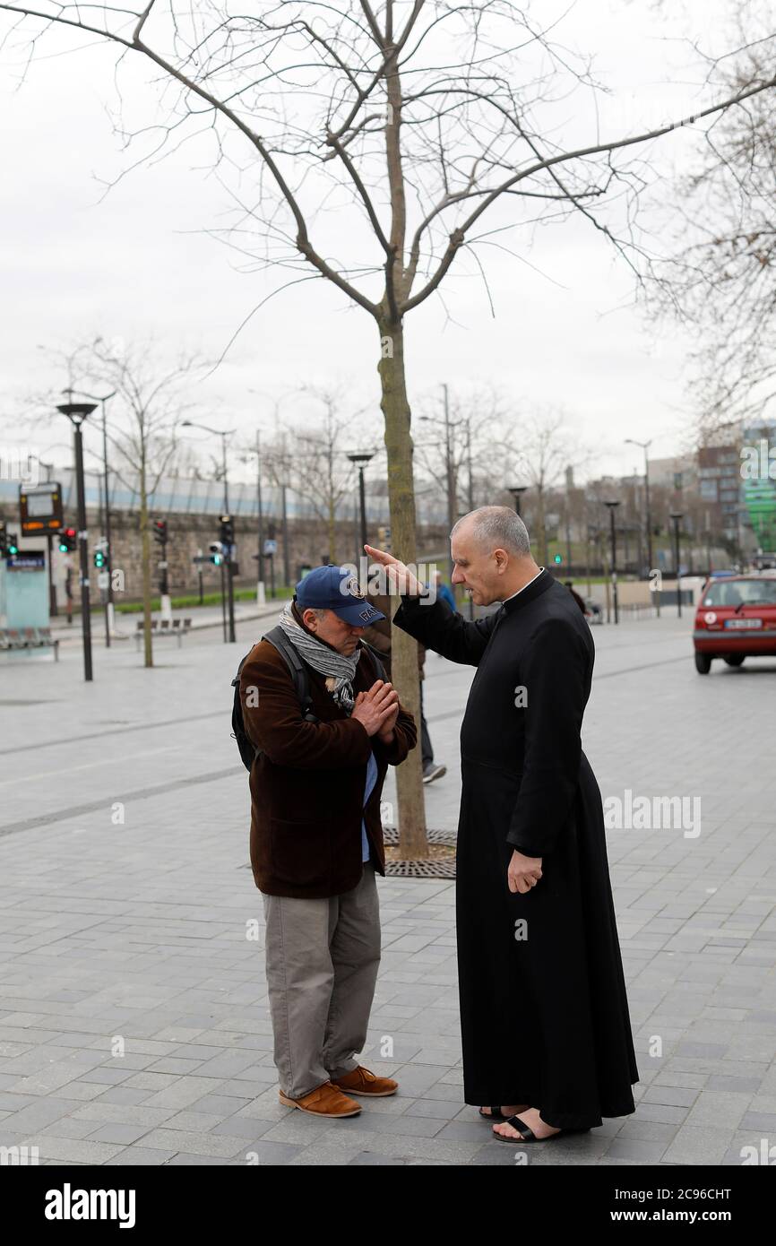 Catholic priest receiving holy confession outside his church in Paris ...