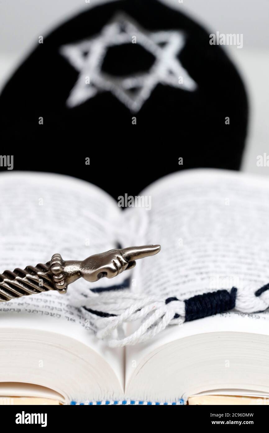 Sylver yad, black and white tzitzit, kippah and Torah. Jewish symbols ...