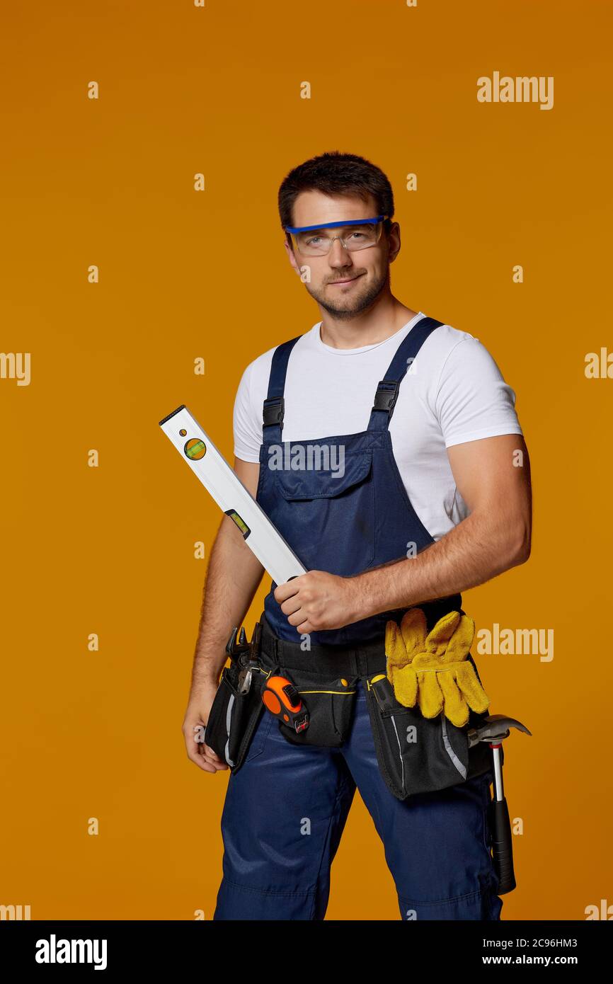 caucasian repairman worker in safety glasses and uniform holding ...
