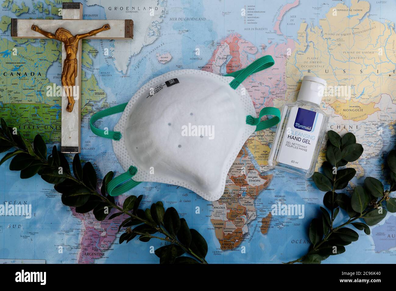 Cross, mask and hand gel over a world map Stock Photo - Alamy