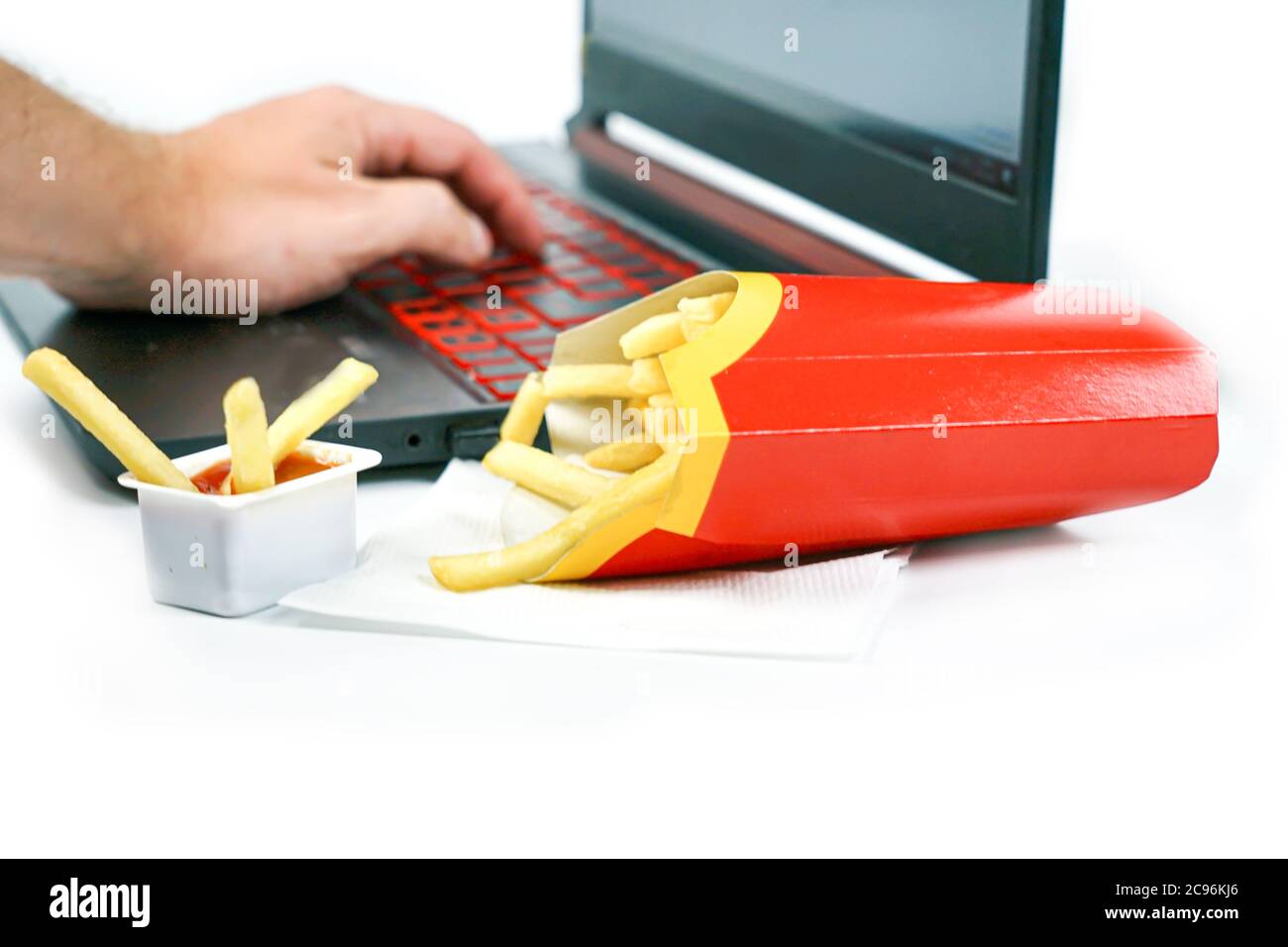 fast food lies near a laptop computer, fries and burger Stock Photo - Alamy