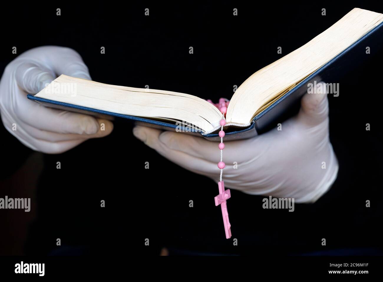 Coronavirus epidemic (COVID-19). Man reading the bible with protective ...