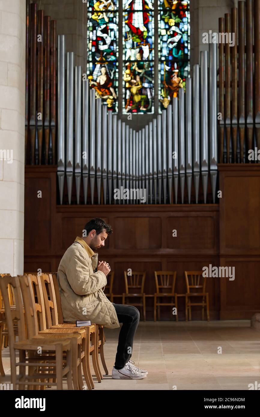 Young man praying in church, Beaumont-le-Roger, France Stock Photo - Alamy