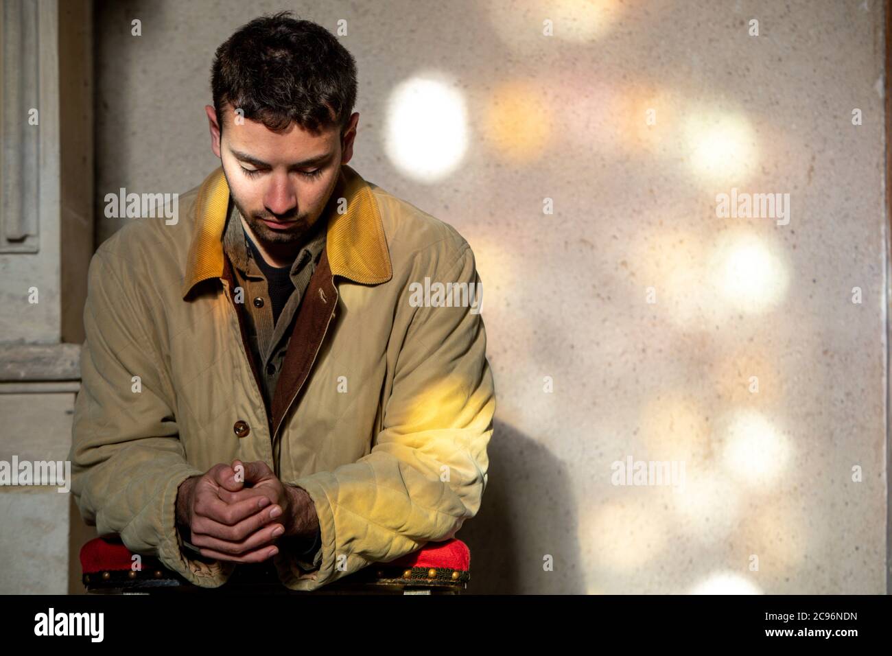 Young man praying in a catholic church, Damville, France Stock Photo ...