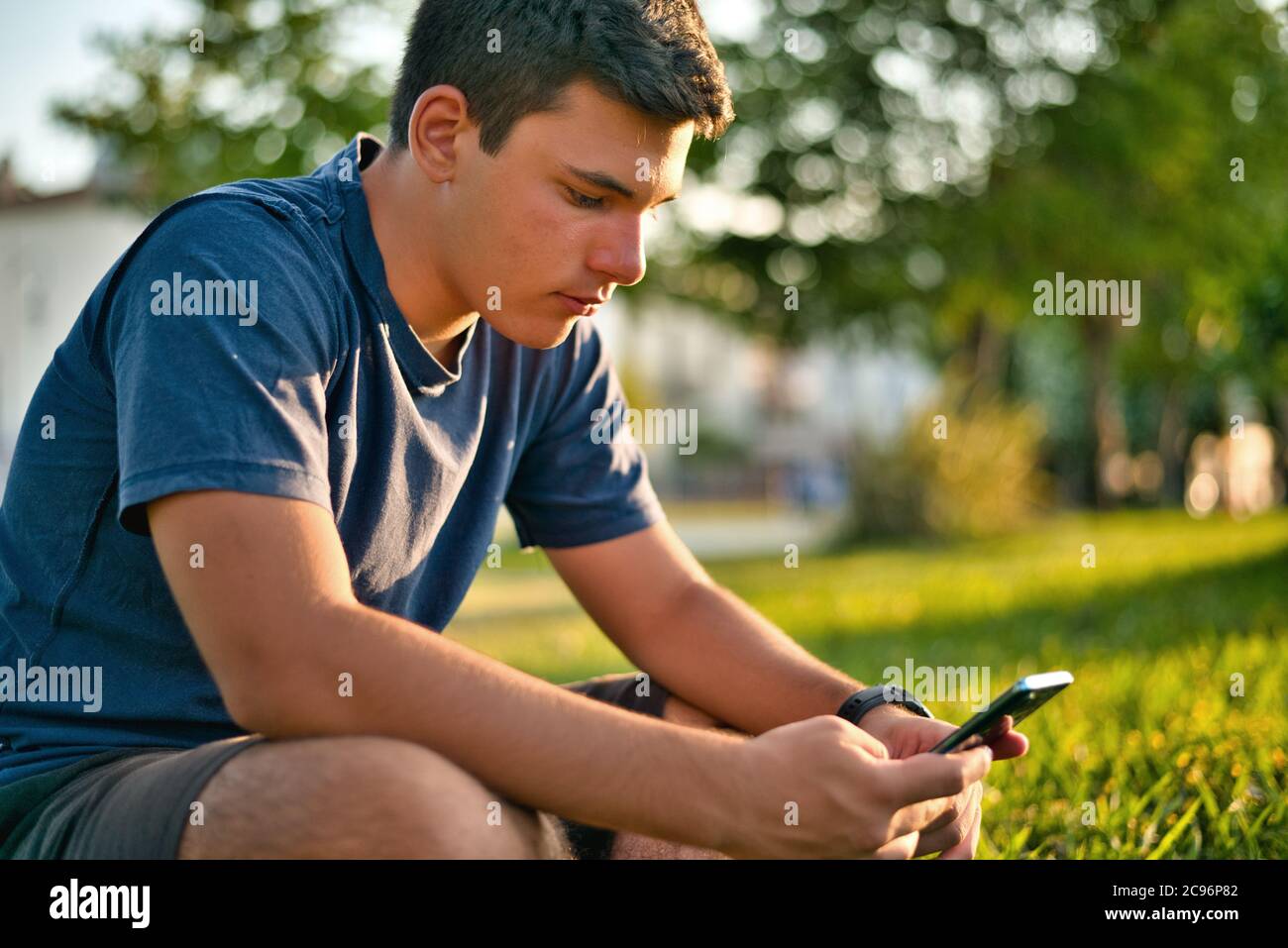 Handsome boy standing holding phone hi-res stock photography and images ...
