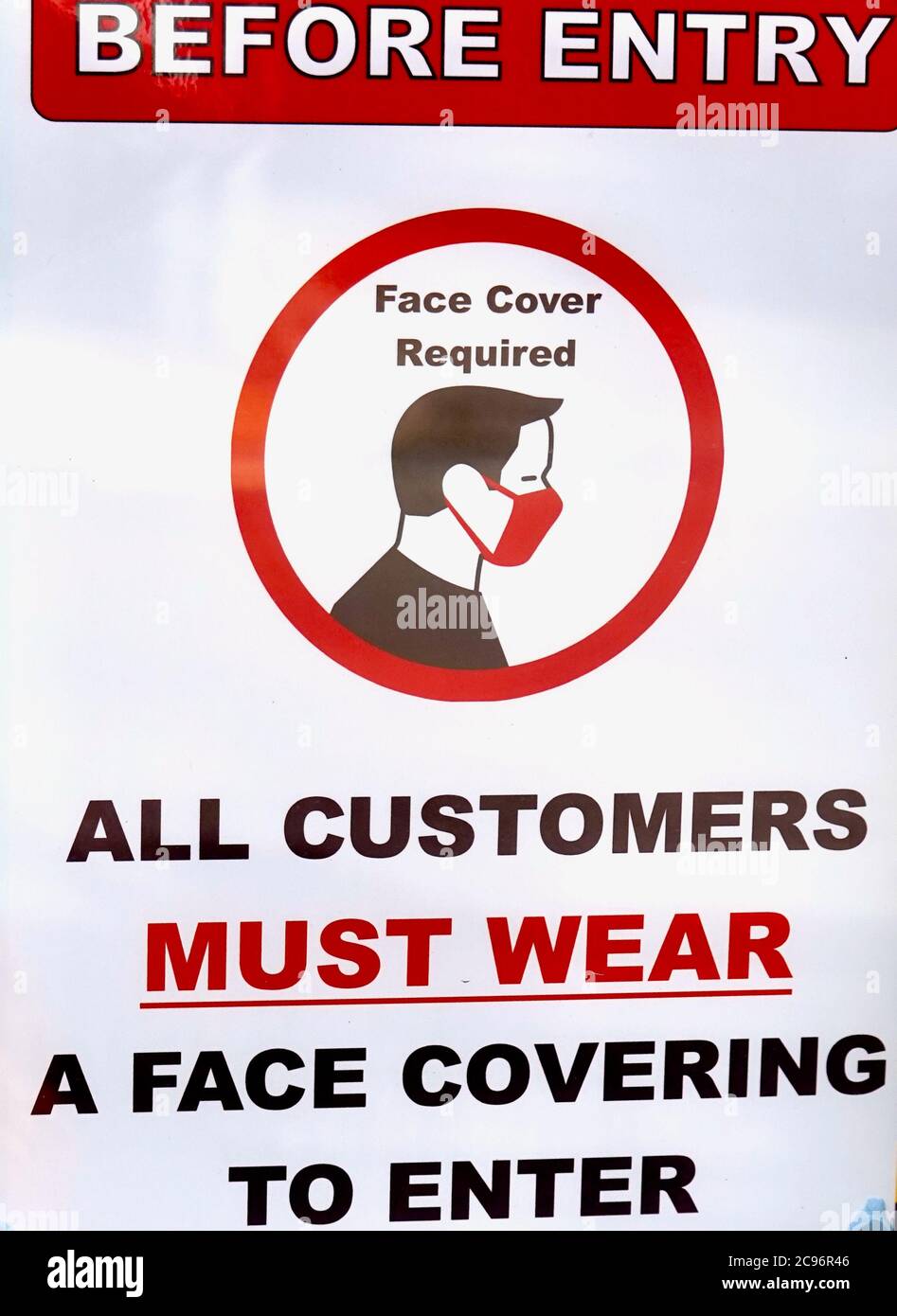 A notice in a shop window reminding customers that face covering is ...