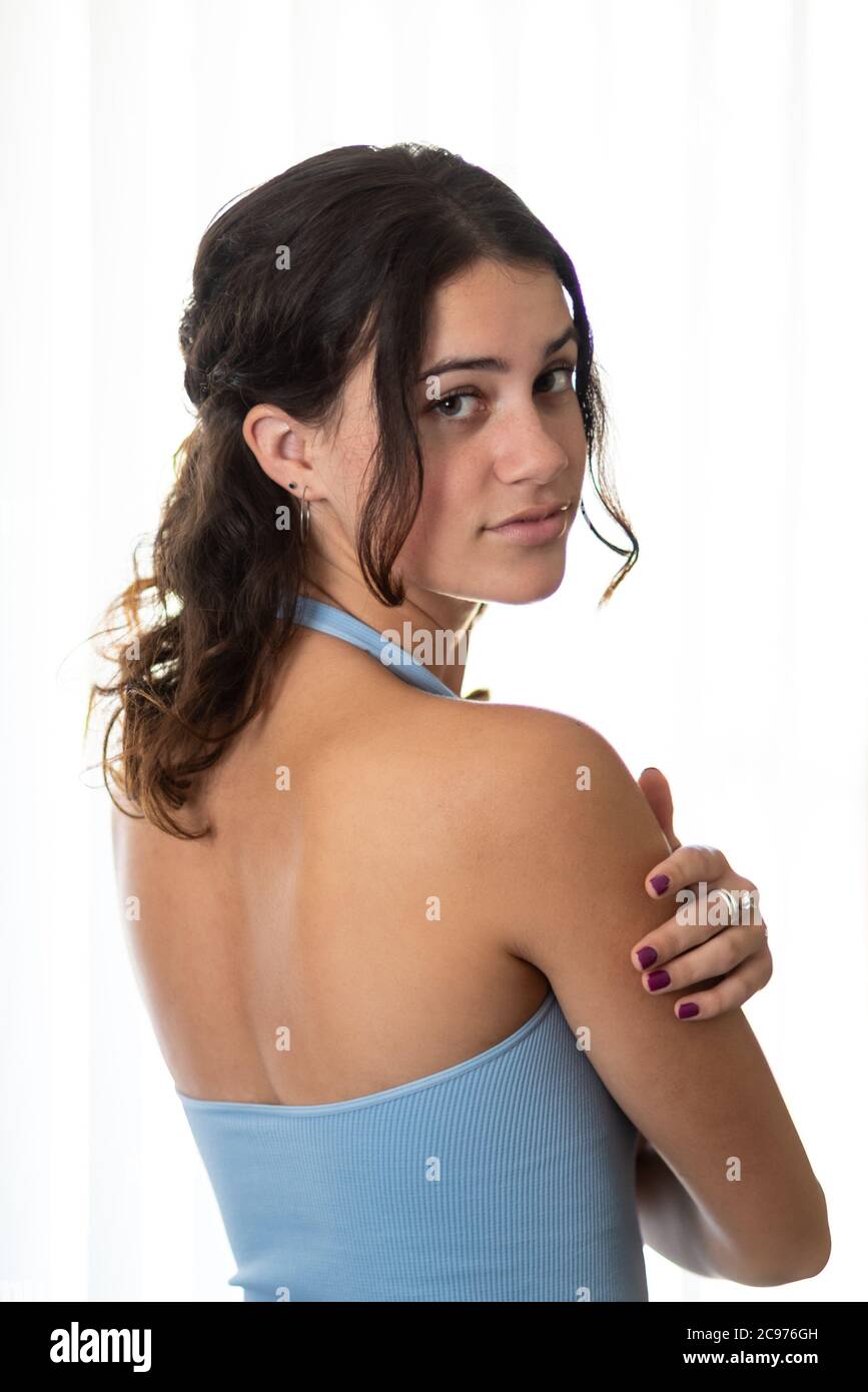 Attractive female teen facing away while looking back over right ...
