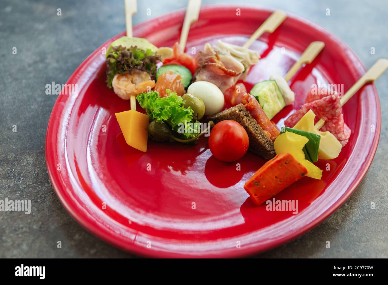 Tapas snack food on sticks.Delicious snacks served on red plate for ...