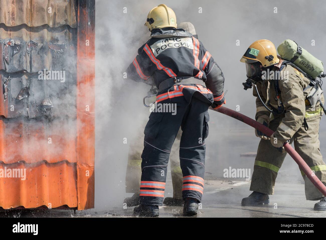Firefighters extinguishing fire from fire hose, using firefighting ...