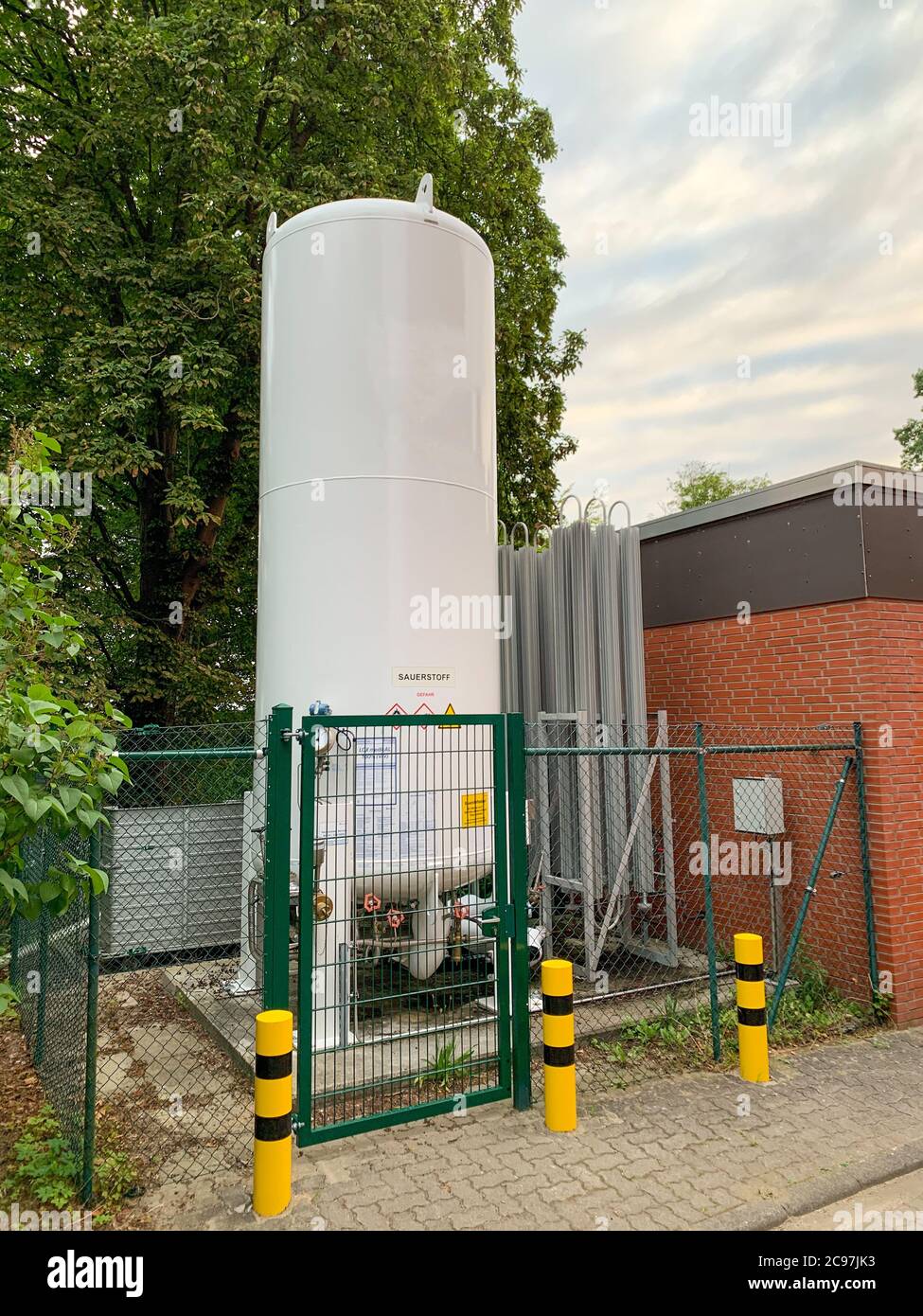 a large white oxygen tank is standing on the grounds of a hospital ...