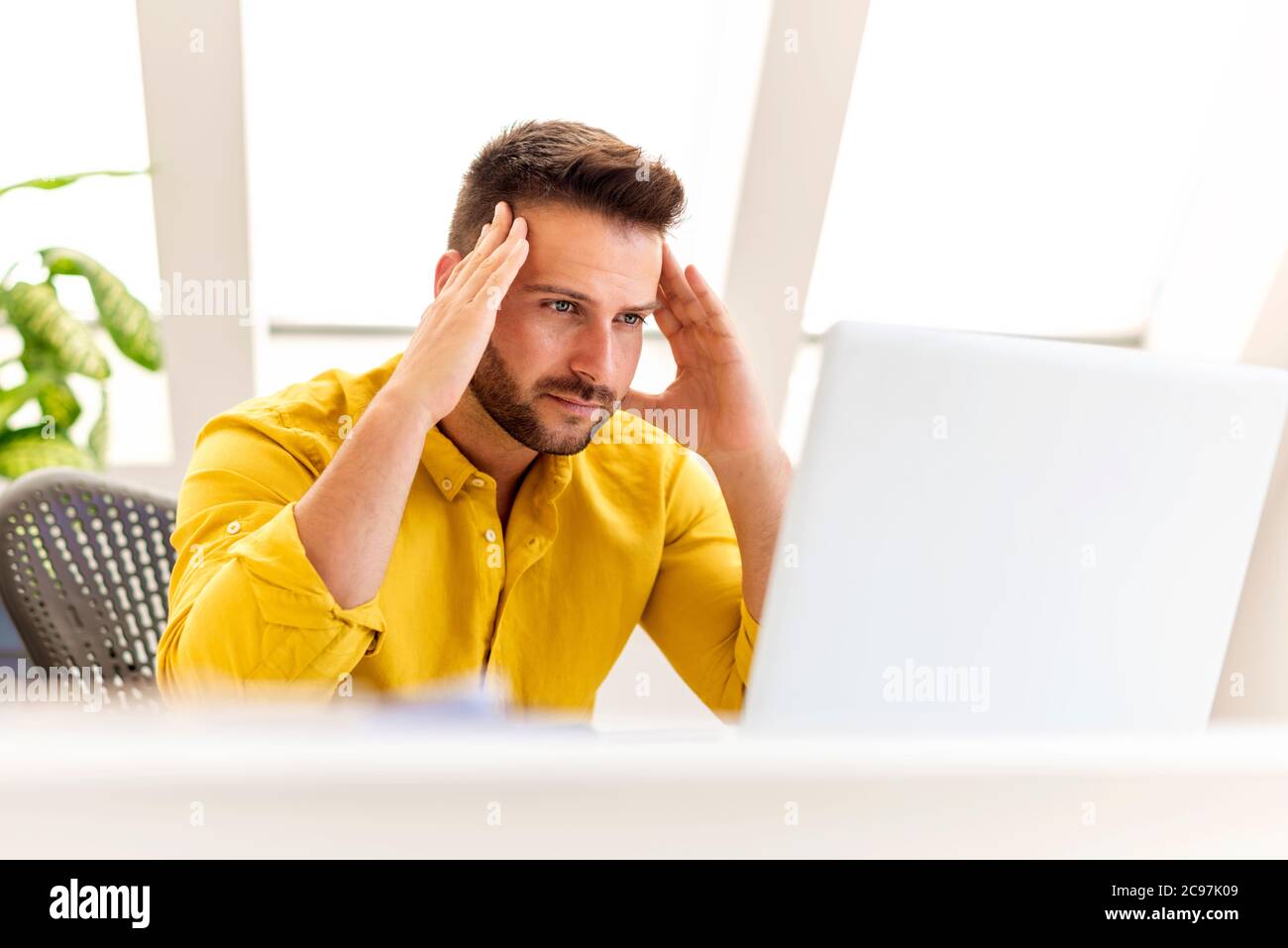 Shot of a businessman experiencing stress during sitting behind his ...