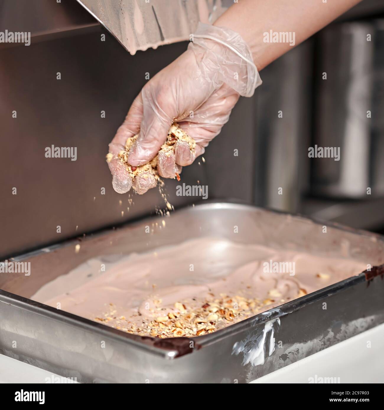 Making Of Ice Cream - Pouring nuts in the steel pan with ice cream in ...