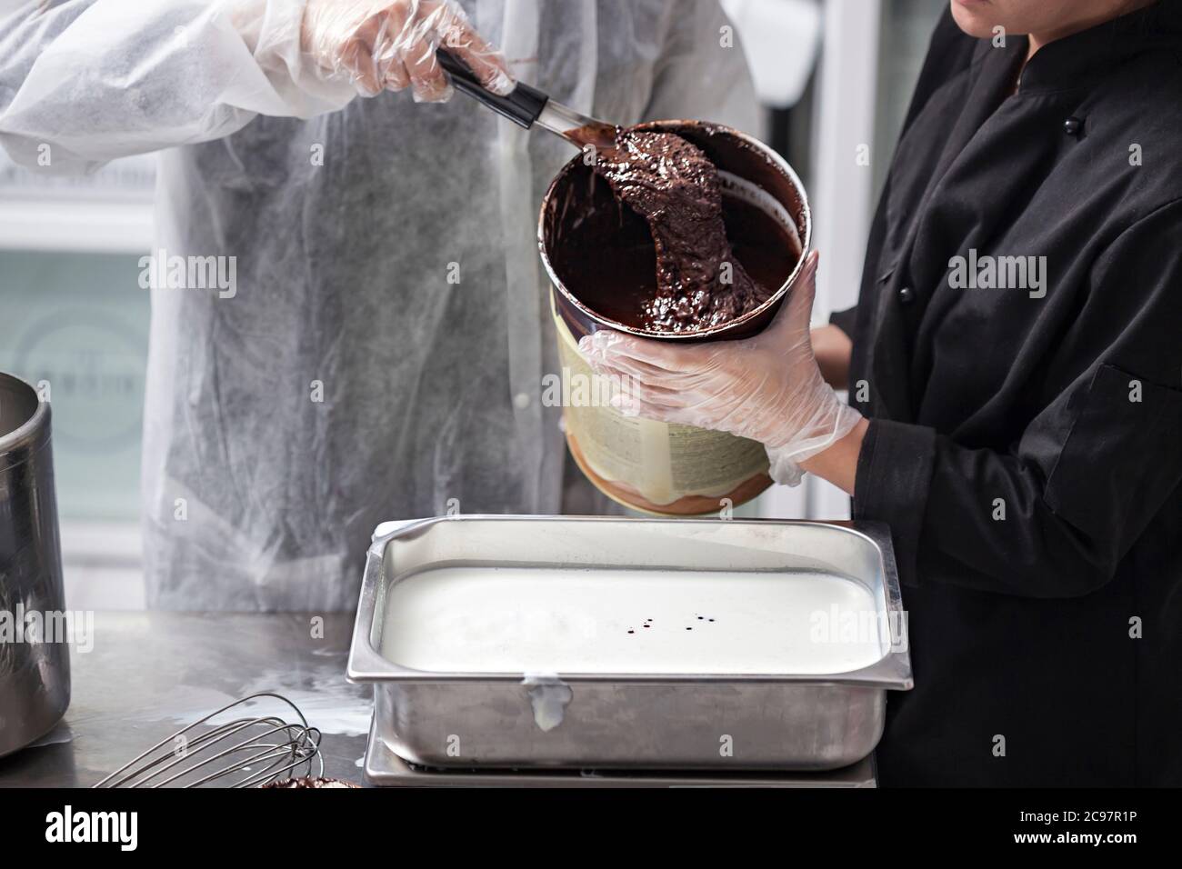 Women hands in gloves preparing chocolate ice cream - pouring chocolate ...