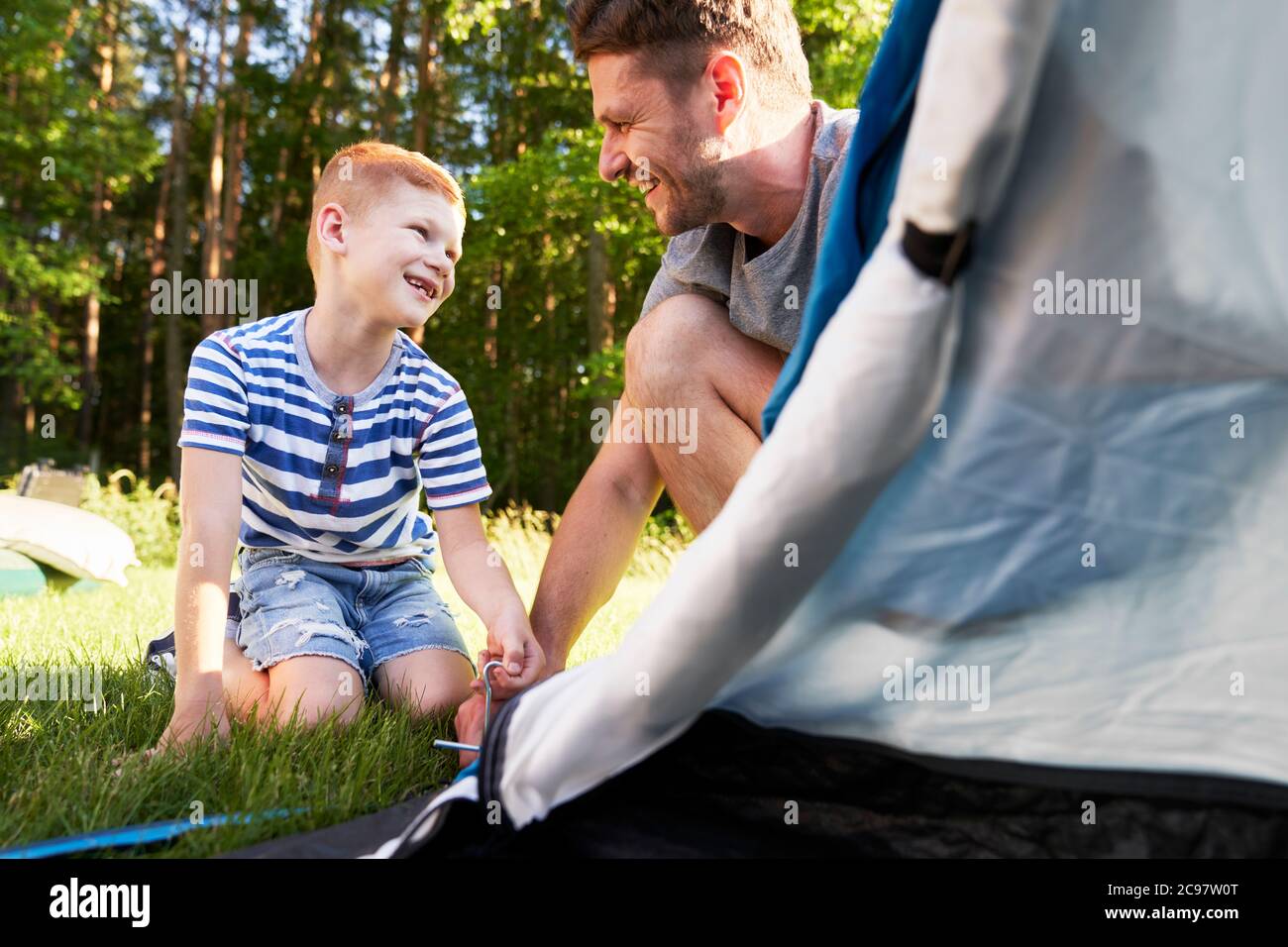 Father and son setting up a tent Stock Photo - Alamy
