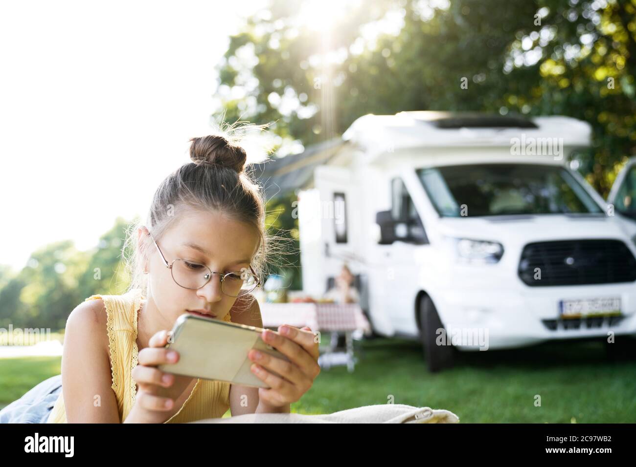 Bored child using mobile phone on holiday time Stock Photo - Alamy