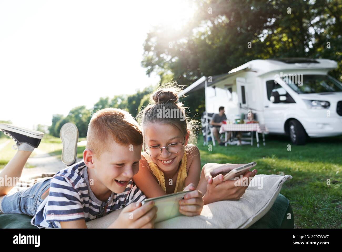 Children using mobile phones while being on camping Stock Photo - Alamy
