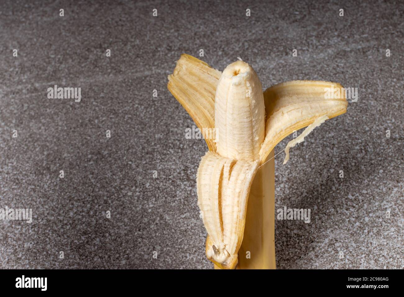 One ripe peeled banana on a gray background. The banana pulp Stock ...