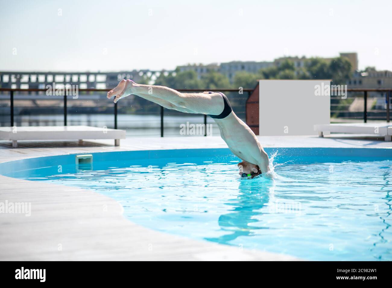 Man in the process of diving in swimming pool Stock Photo - Alamy