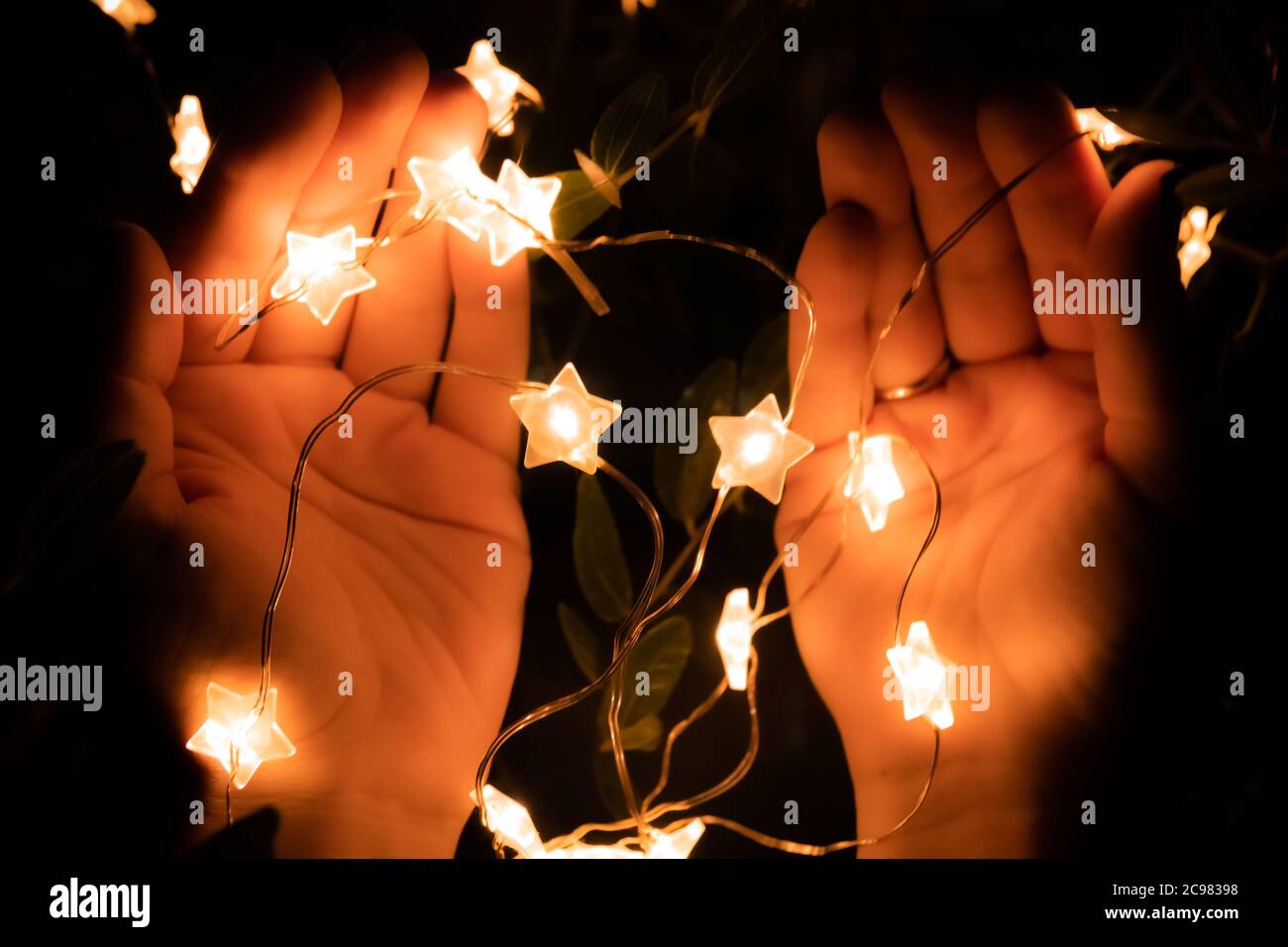 Yellow Led star shape light on hands in shape of pray for background ...