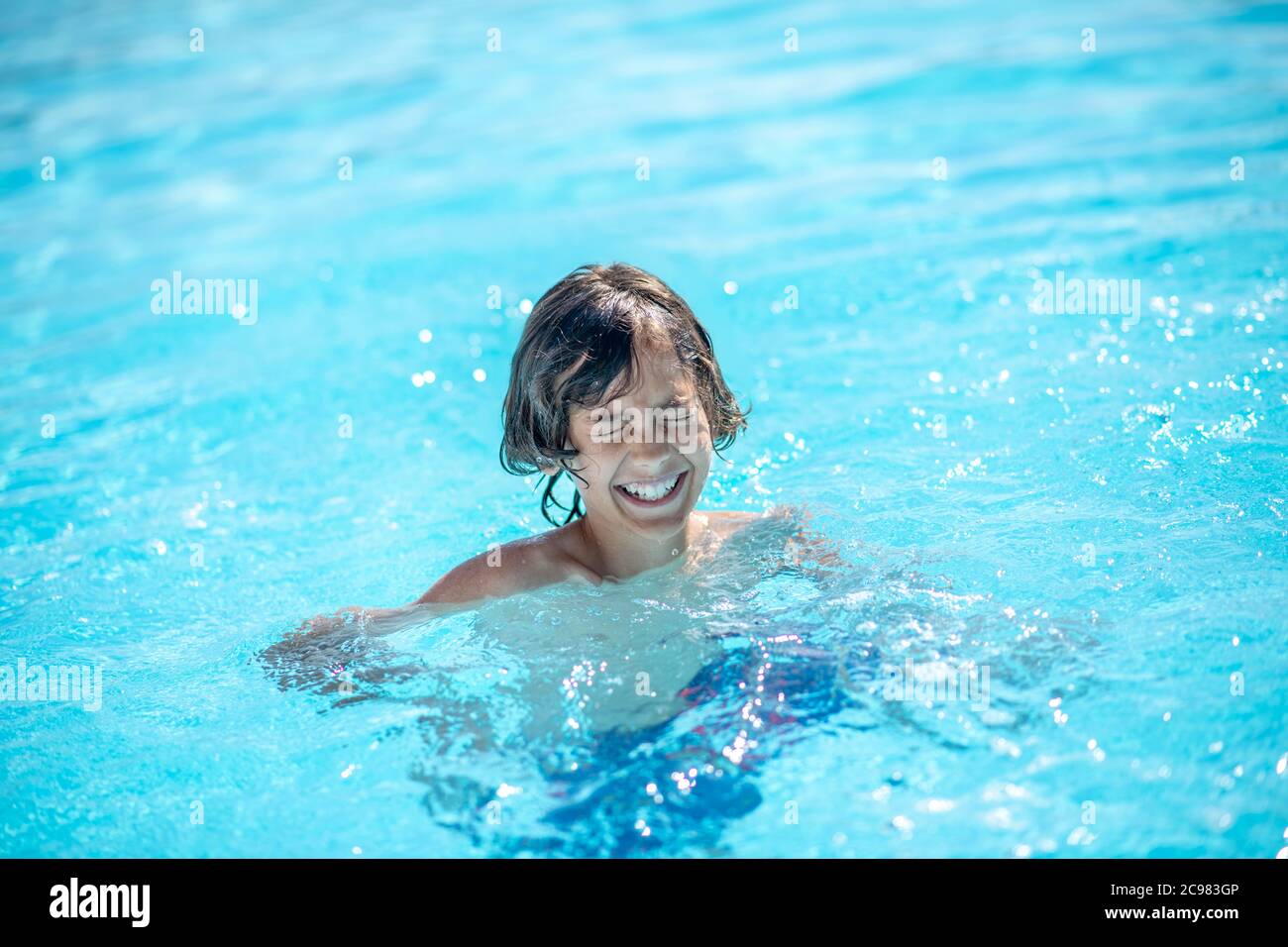Boy in water smiling with closed eyes Stock Photo - Alamy