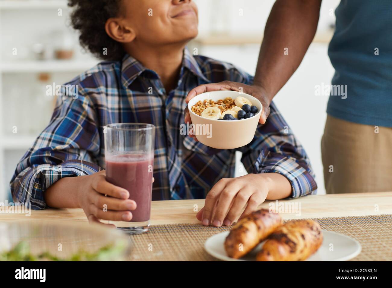 Close-up of African boy eating cereal and drinking fresh juice for ...