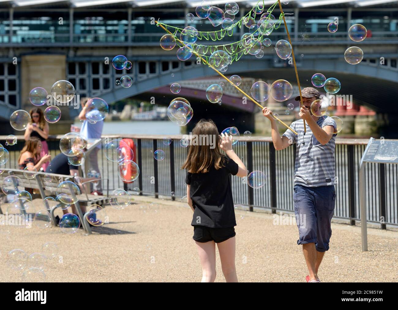 London, England, UK. Street entertainer on the South Bank blowing ...