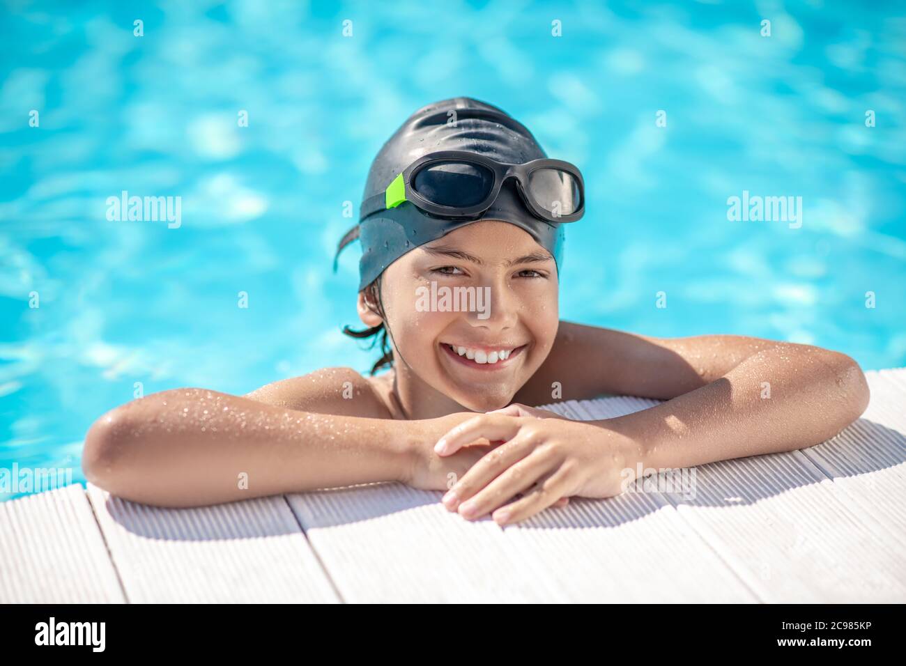 Boy in swimming cap and goggles by pool Stock Photo - Alamy